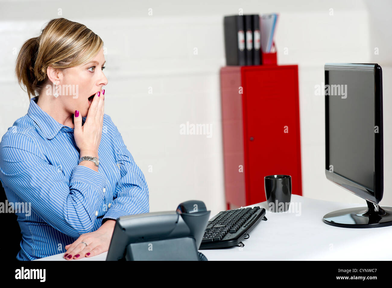 Shocked businesswoman looking at annual reports on computer screen ...