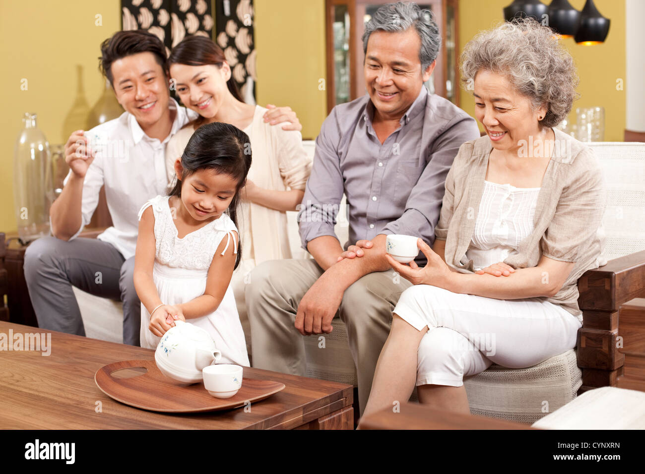 Cute girl making tea for family Stock Photo - Alamy