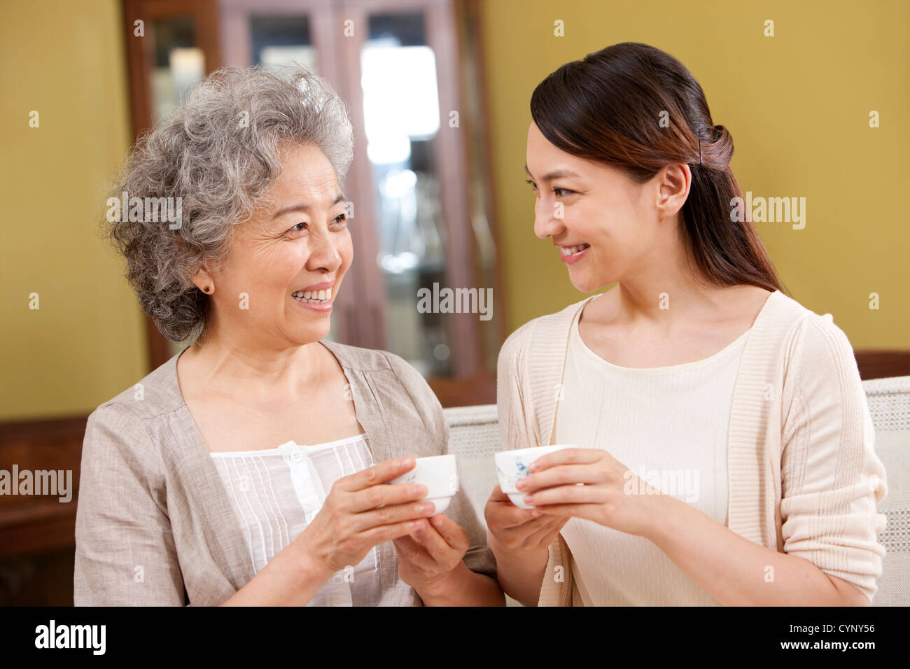 Young woman having tea with mother Stock Photo - Alamy