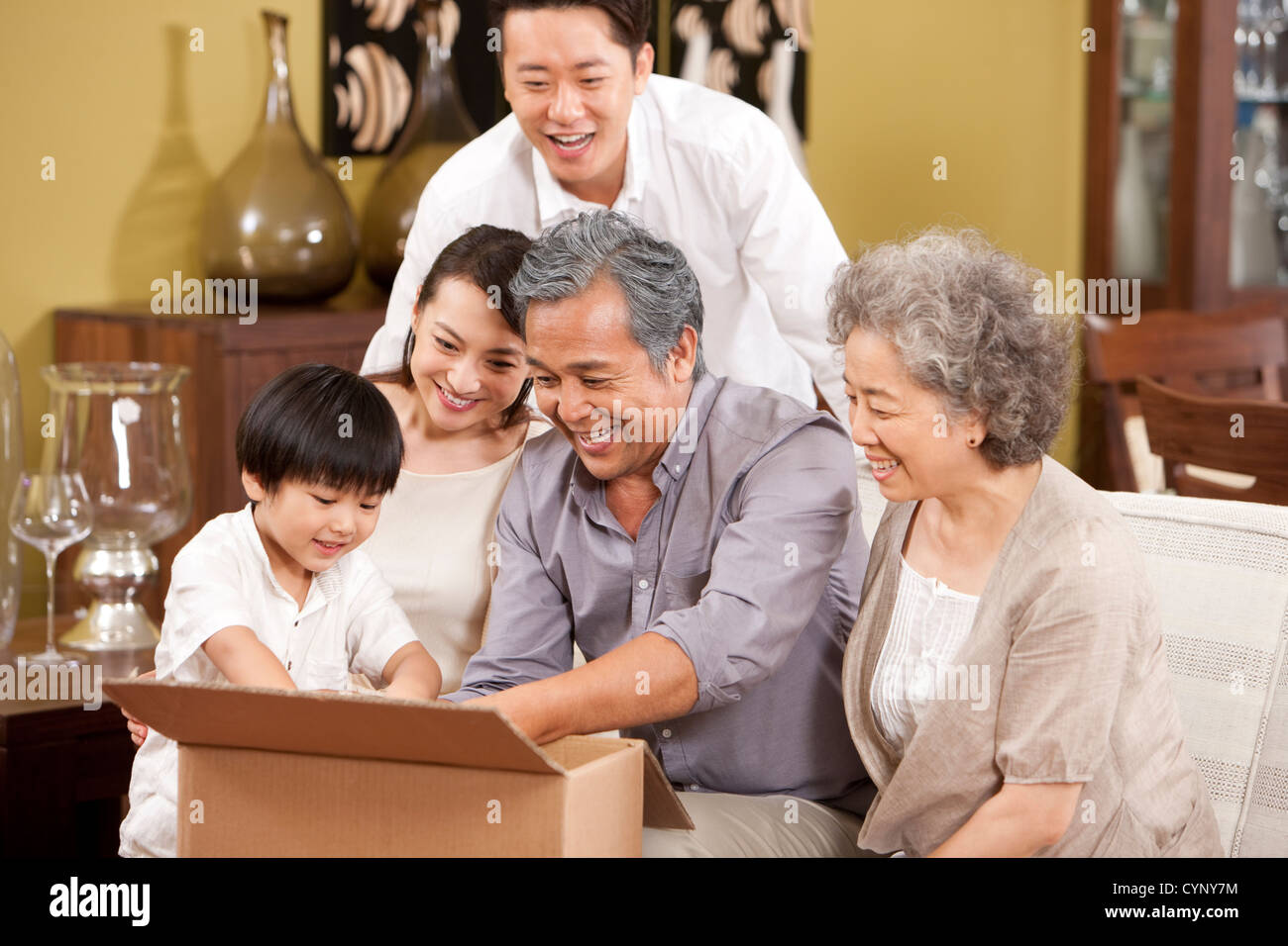 Happy family opening a carton Stock Photo - Alamy