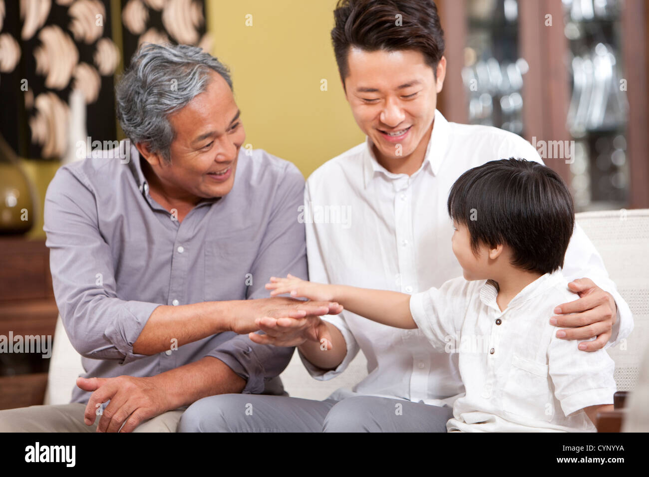 Three generations of men having fun at home Stock Photo - Alamy