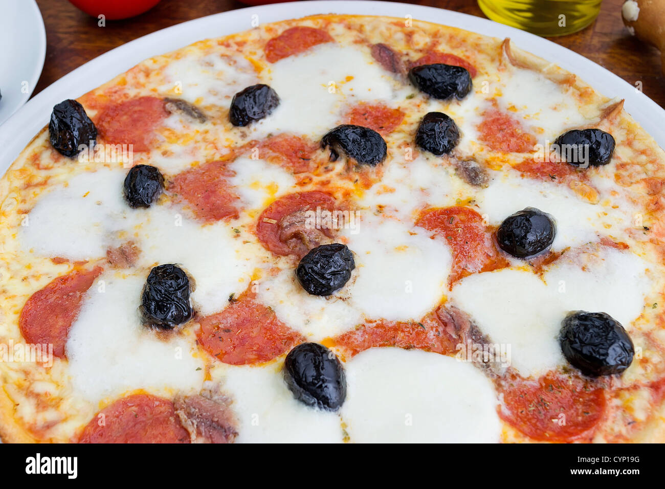 pizza with olives, pepperoni and anchovies Stock Photo - Alamy
