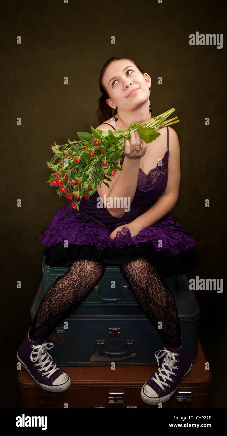 Pretty girl in funky purple outfit on green background with flowers ...