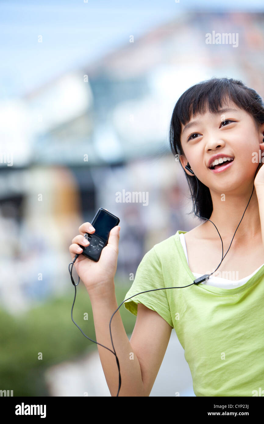 Schoolgirl listening to MP3 player Stock Photo - Alamy