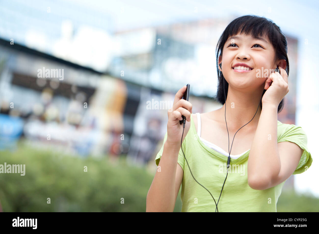 Schoolgirl listening to MP3 player Stock Photo - Alamy