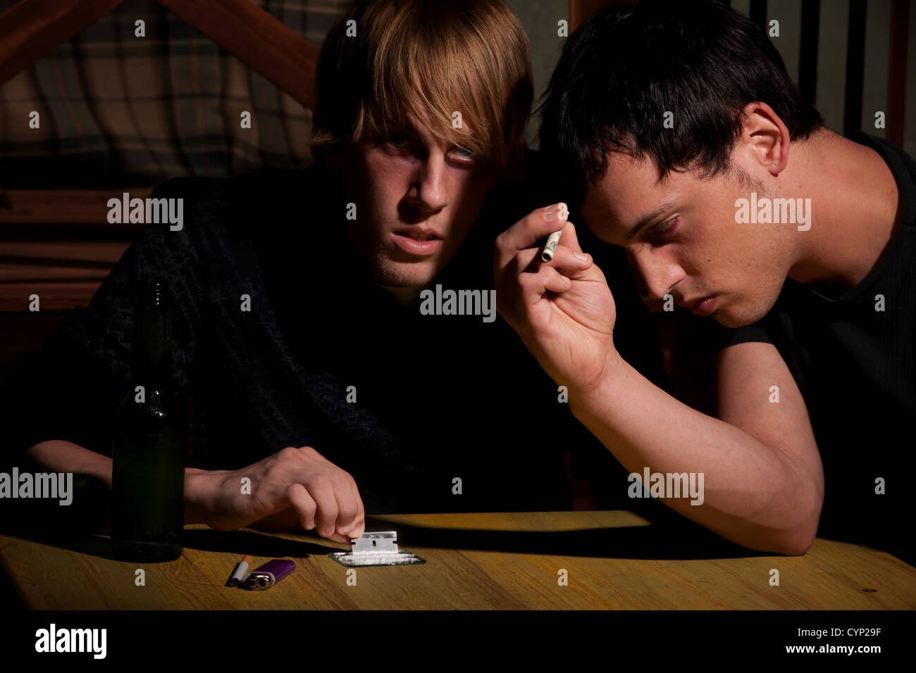 Two young men with heroin or cocaine on table Stock Photo - Alamy