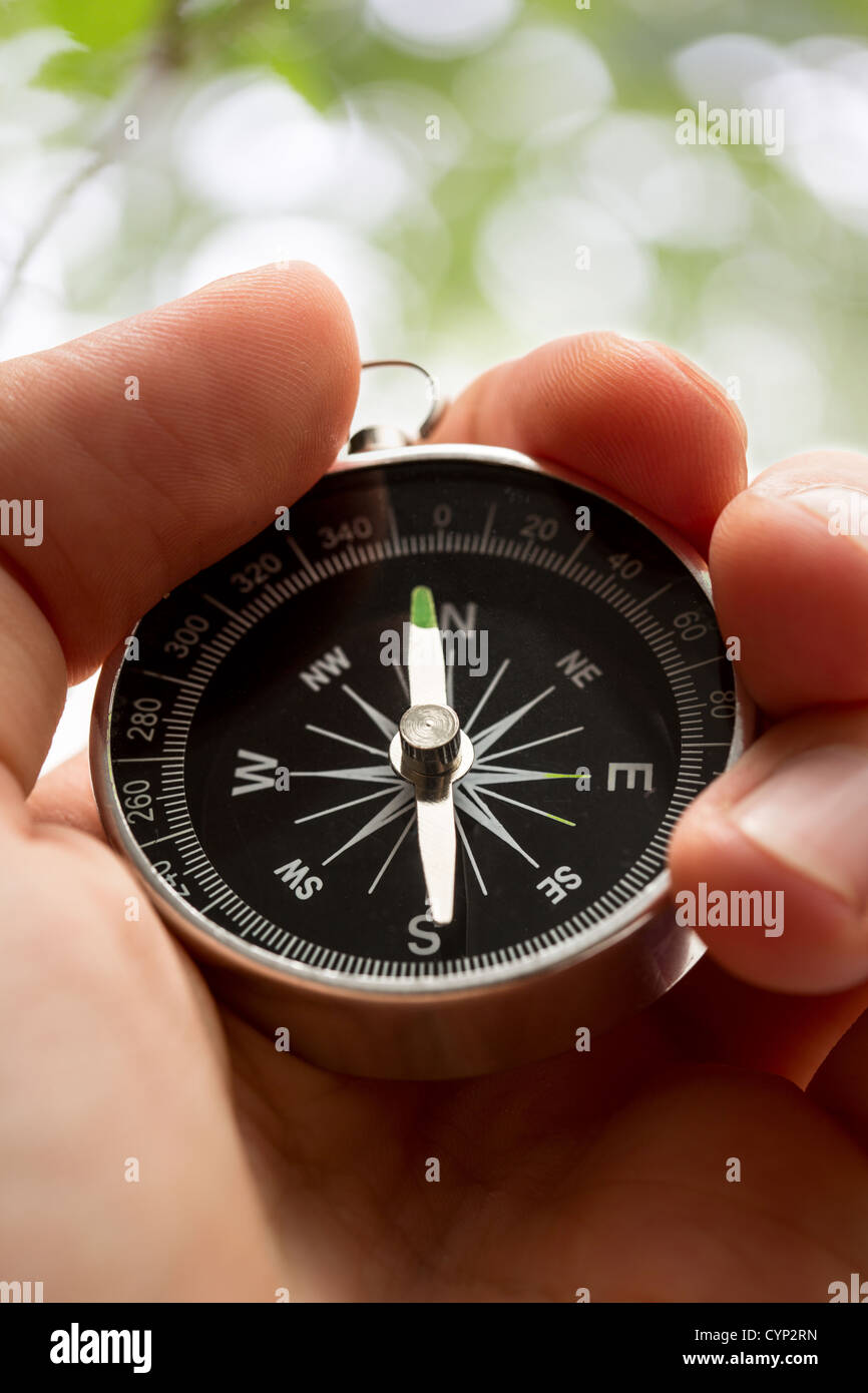 Hand holding silver black compass Stock Photo - Alamy