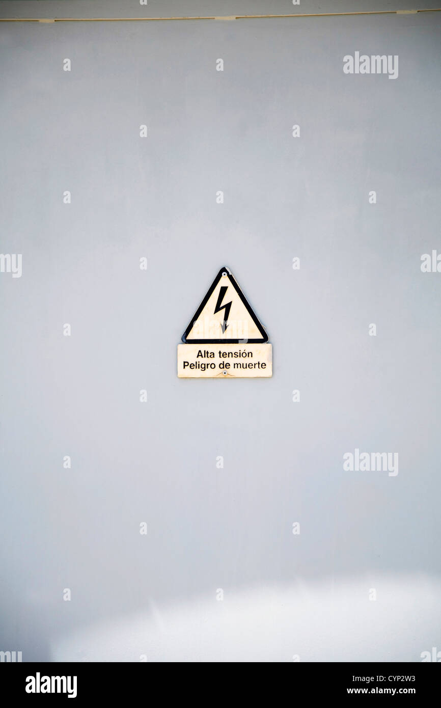 danger high tension sign on a grey wall Stock Photo - Alamy