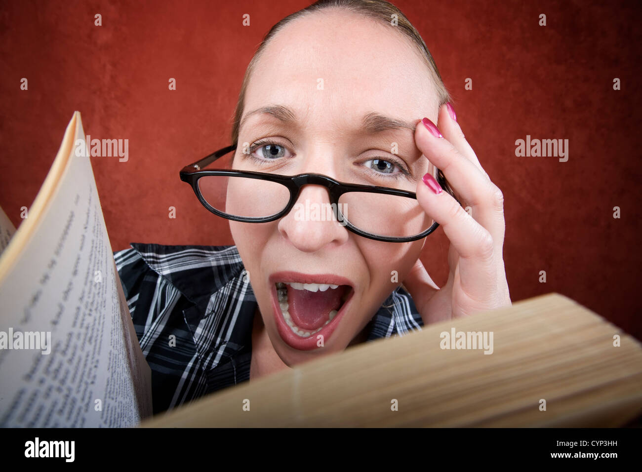 Screaming woman with big eyes and glasses reading a book Stock Photo ...