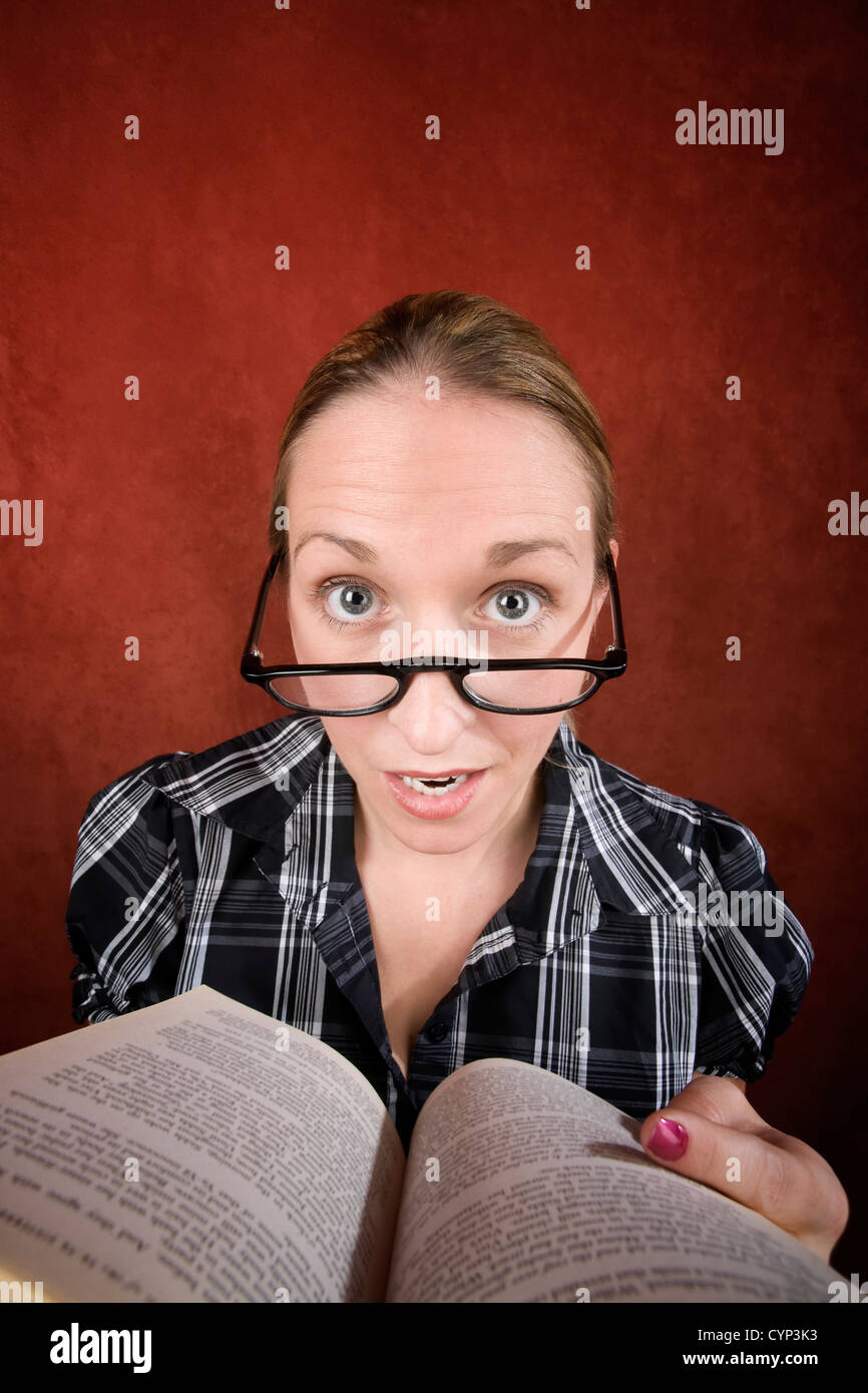Woman with big eyes and glasses reading a book Stock Photo - Alamy
