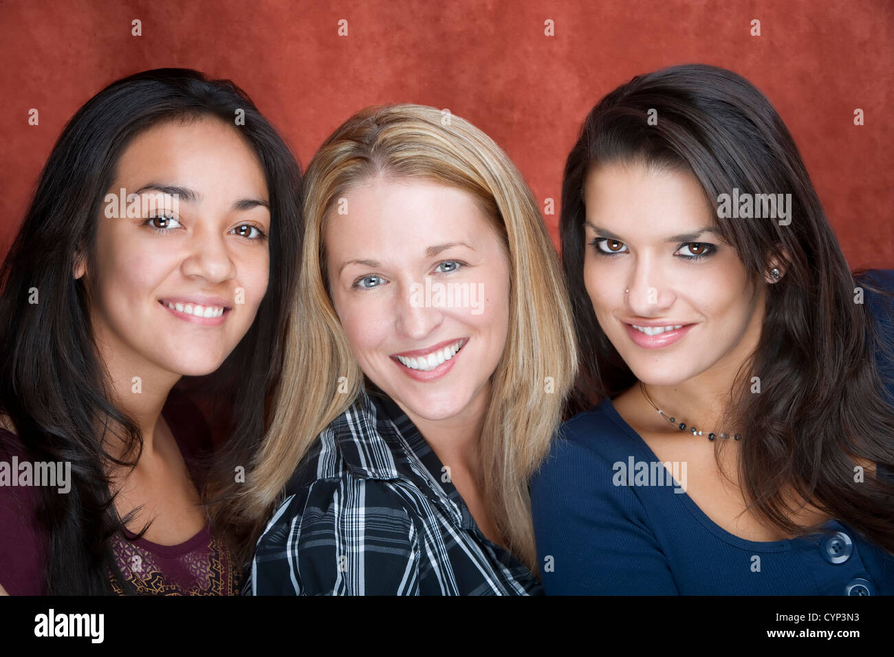 Three pretty women smiling in a studio setting Stock Photo - Alamy