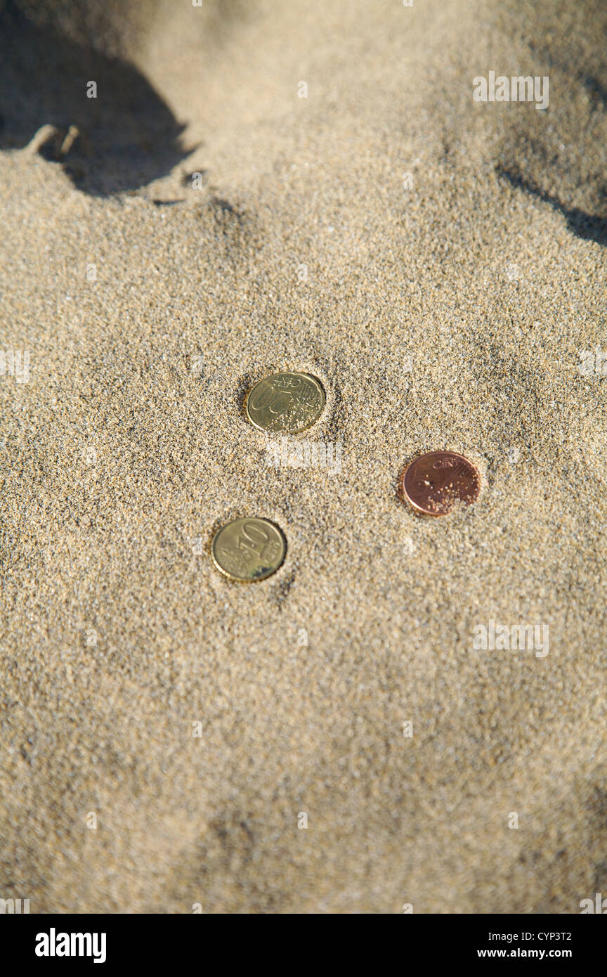 three euro coins at the sand of a beach Stock Photo - Alamy