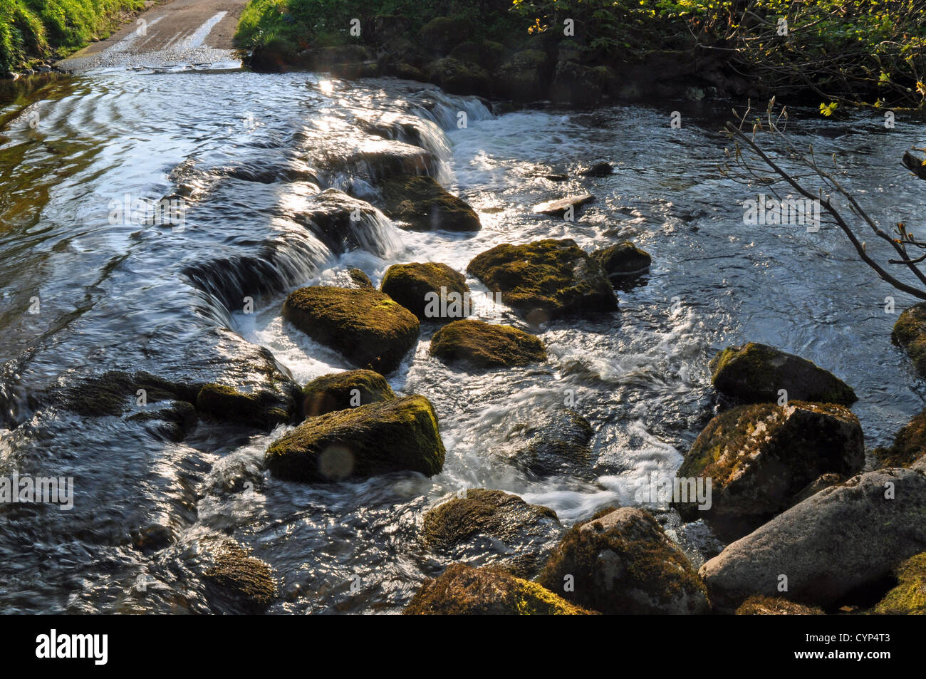 A stream passes over rocks near a ford in the road Stock Photo - Alamy
