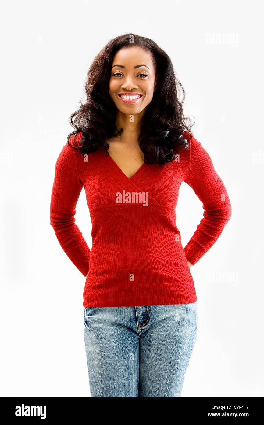 Beautiful African woman standing with hands behind back and smiling ...