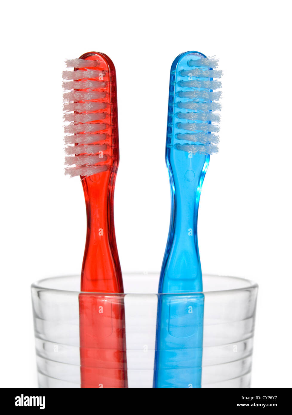 Two toothbrushes in a glass over white background Stock Photo - Alamy