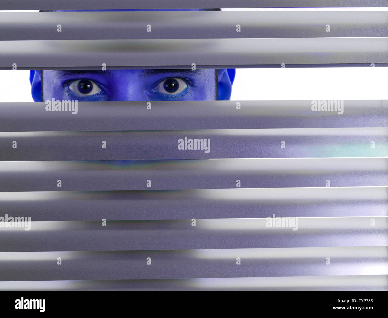 A blue man looks to the camera through the blinds Stock Photo - Alamy