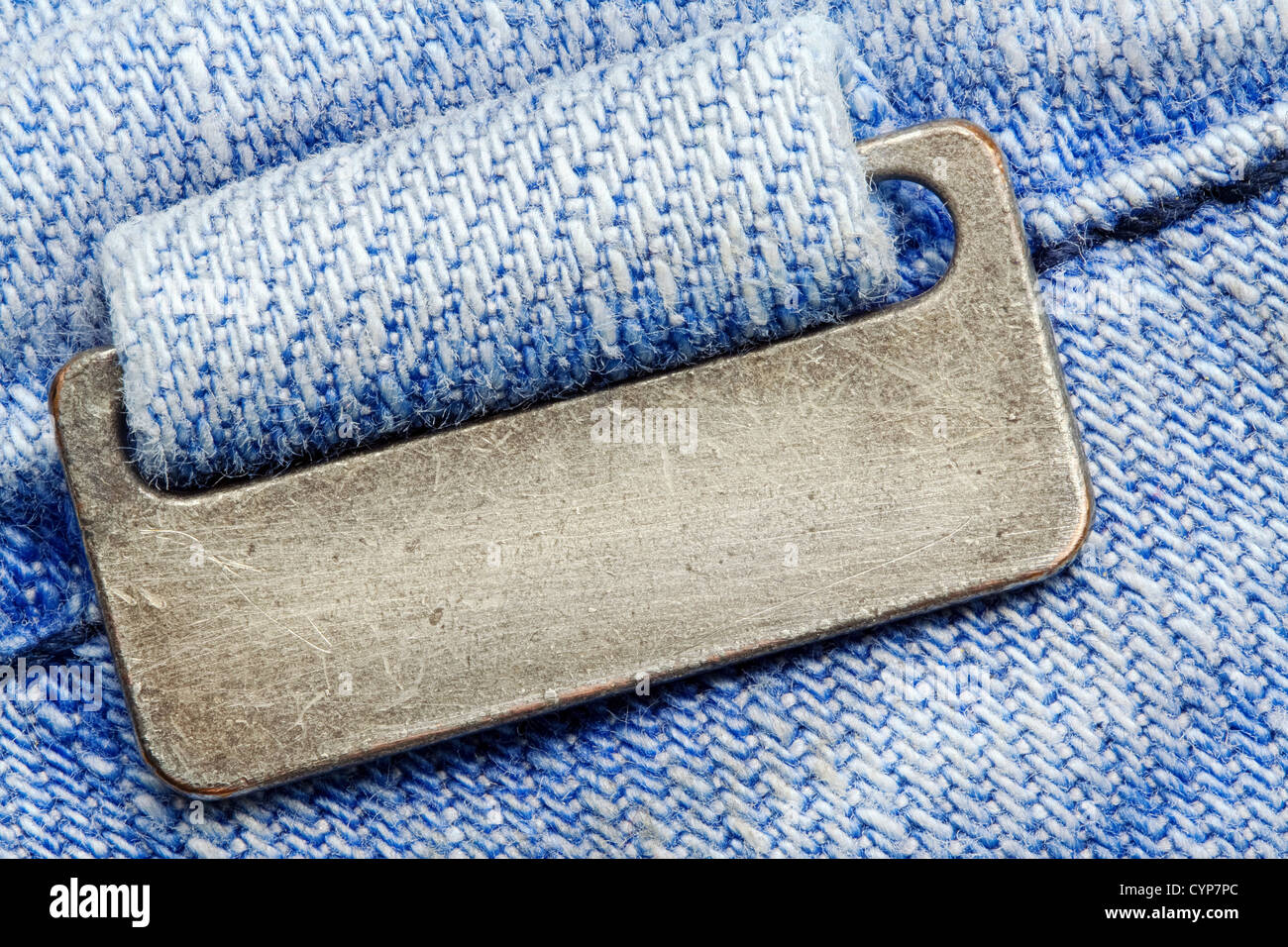 Metal tag on blue denim jeans Stock Photo - Alamy