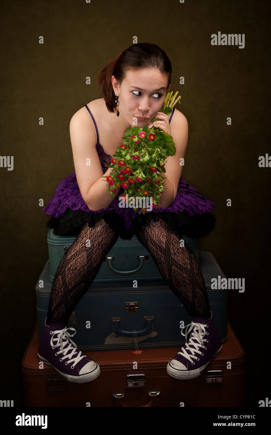 Pretty girl in funky purple outfit on green background with flowers ...