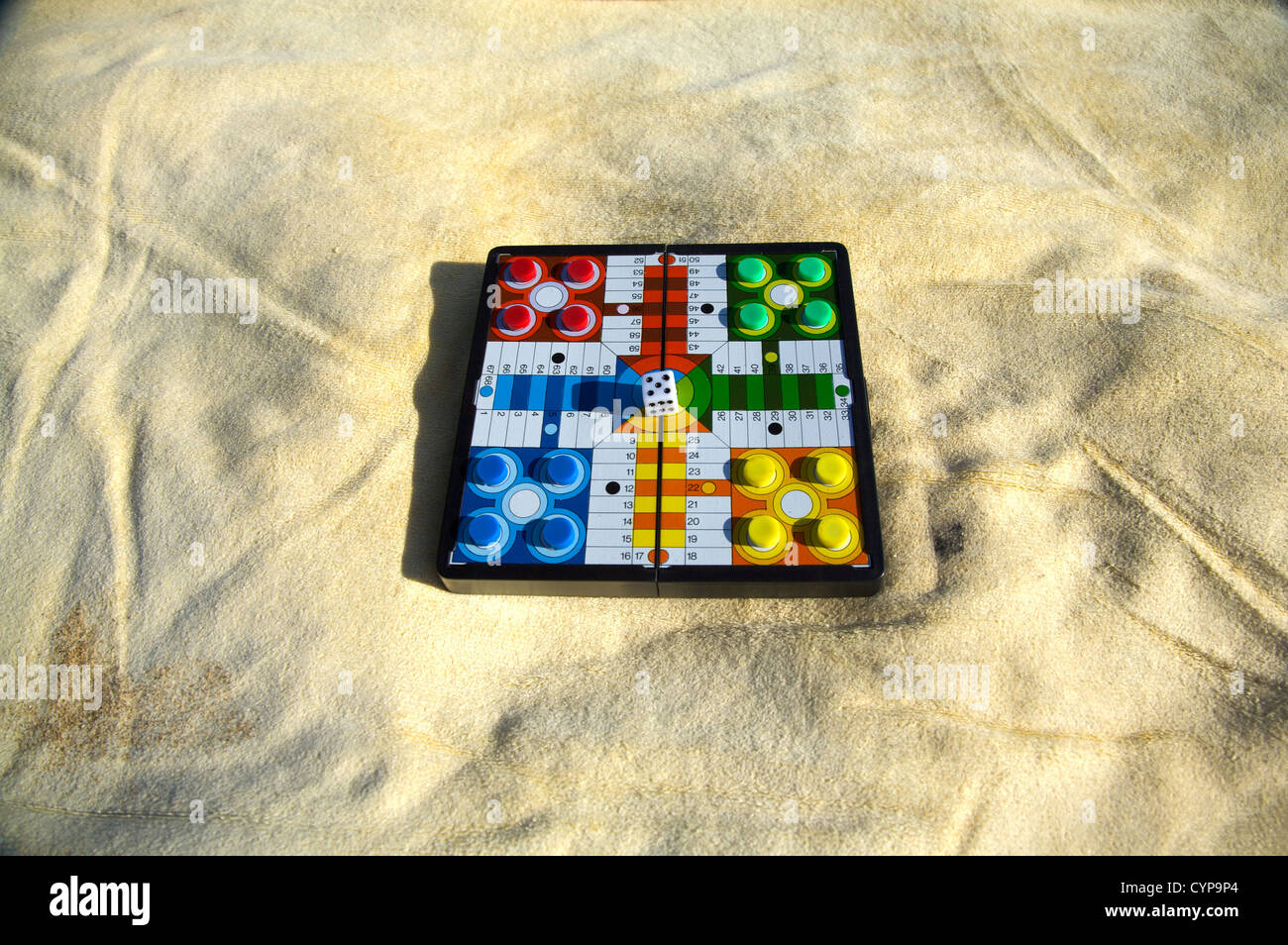 Parcheesi prepared on a yellow towel at the beach Stock Photo - Alamy