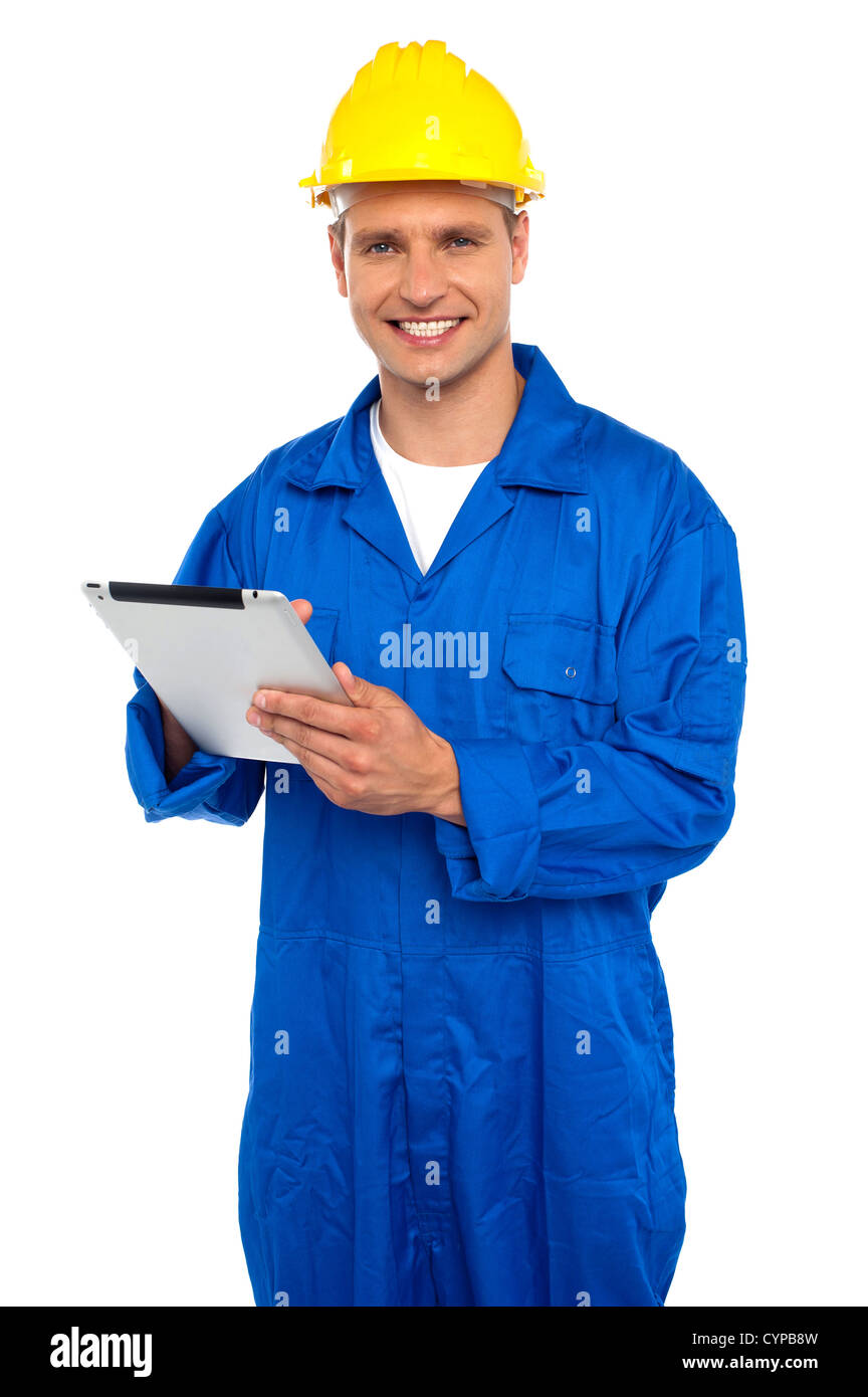 Handsome industrial contractor using wireless tablet device, looking at ...