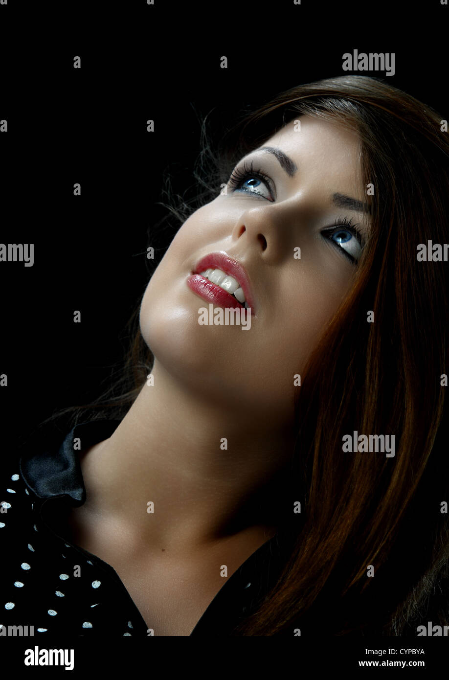 Beautiful woman looks upwards Stock Photo - Alamy