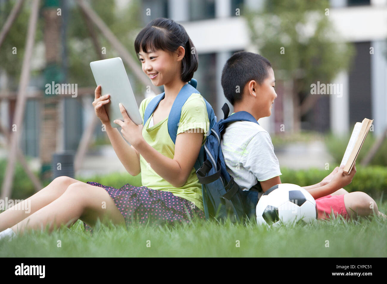 Schoolchildren learning with books and digital tablet Stock Photo - Alamy