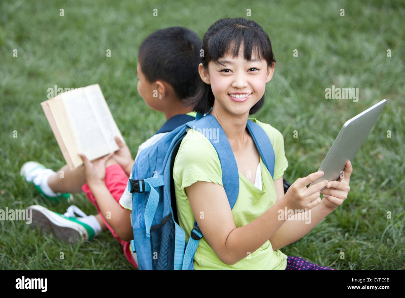 Schoolchildren learning with books and digital tablet Stock Photo - Alamy