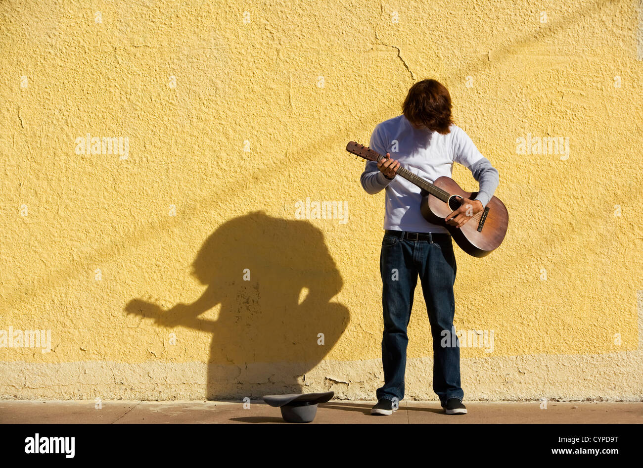 Young male musician alone on the sidewalk with guitar Stock Photo - Alamy