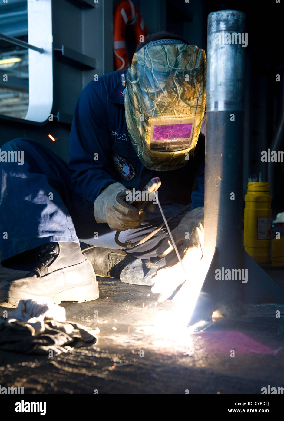 Hull Maintenance Technician 3rd Class Ron Stocker welds a chair to the ...