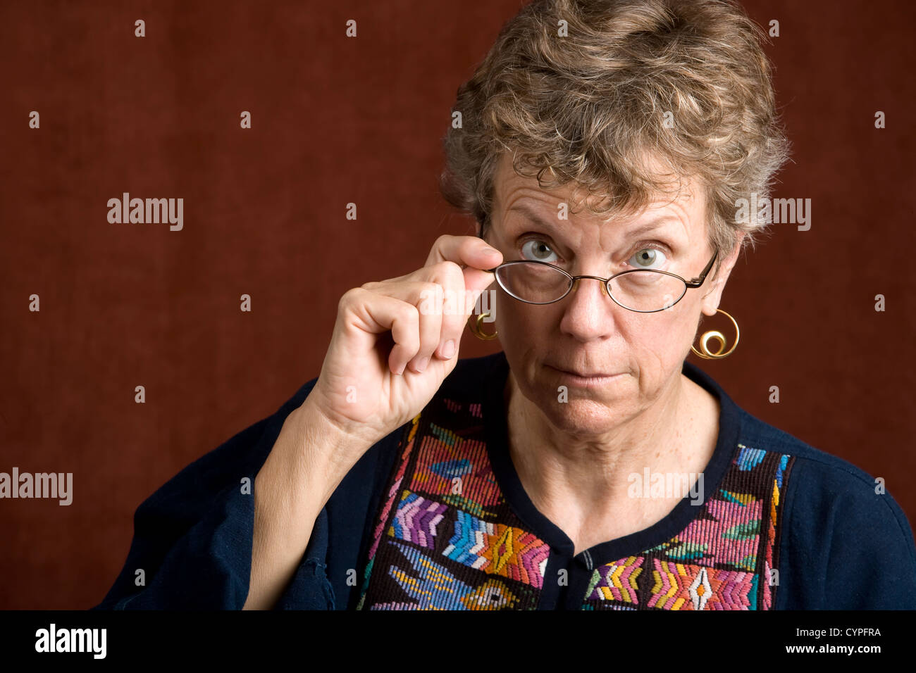 Senior woman looking over the top of her glasses Stock Photo - Alamy