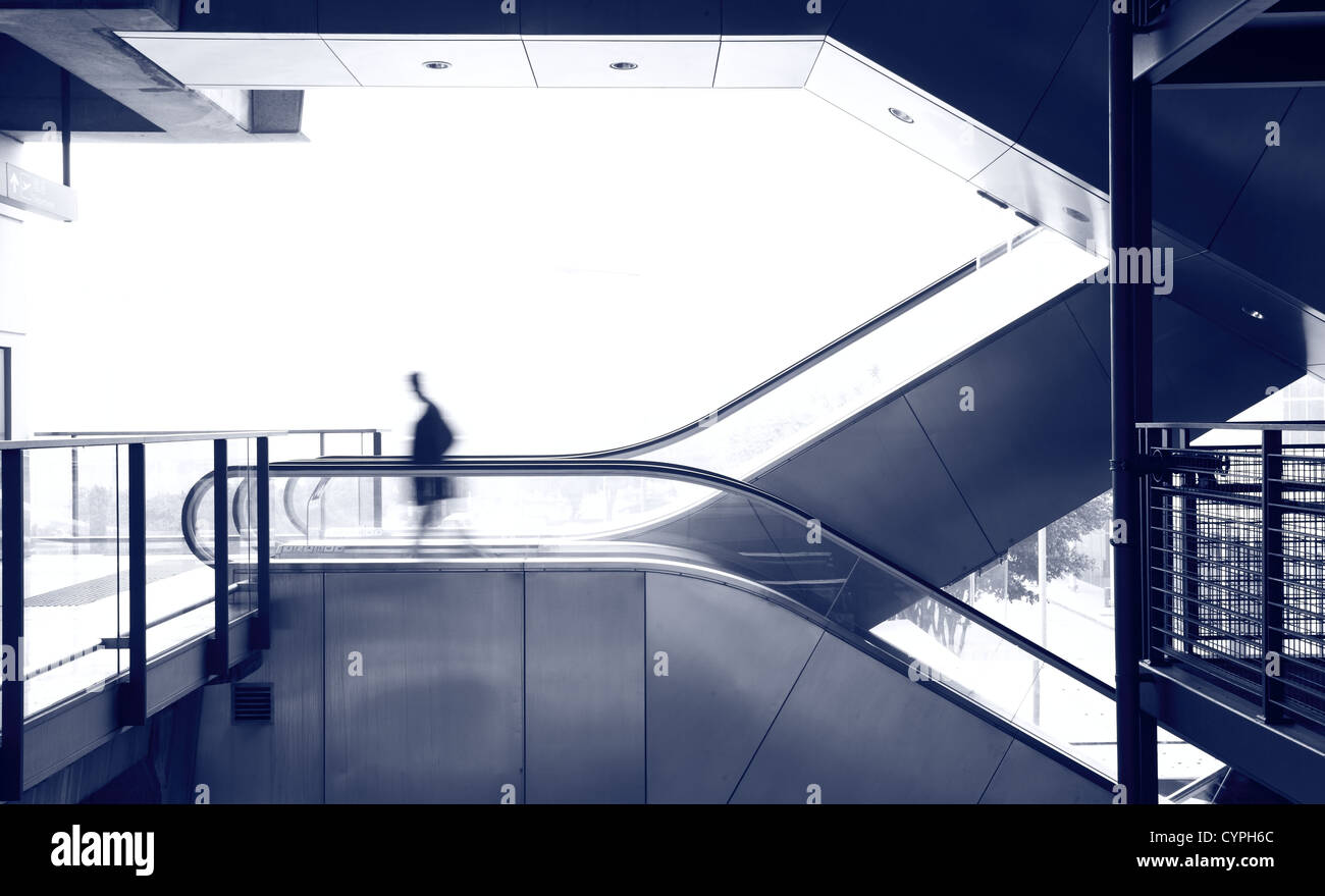 business man move on escalator, blue tone Stock Photo - Alamy
