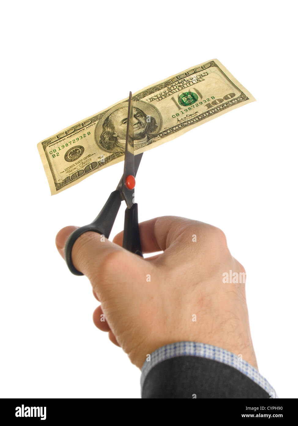 A man's hand cutting a one hundred dollar bill with a pair of scissors ...