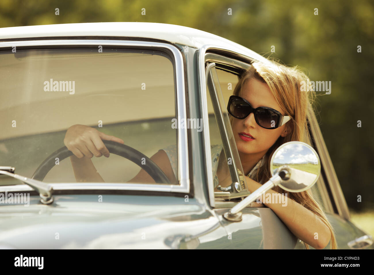 Young woman driving vintage car Stock Photo - Alamy