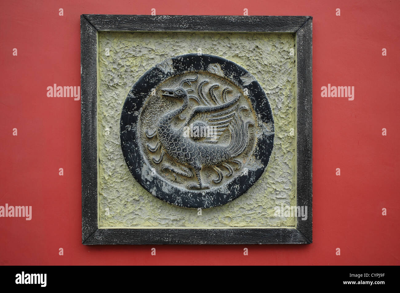 bronze phoenix sculpture on a red wall Stock Photo - Alamy