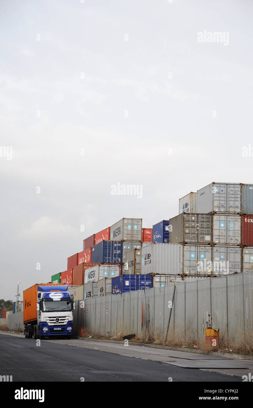 Lorry parked in a depot next to large cargo shipping containers Stock ...