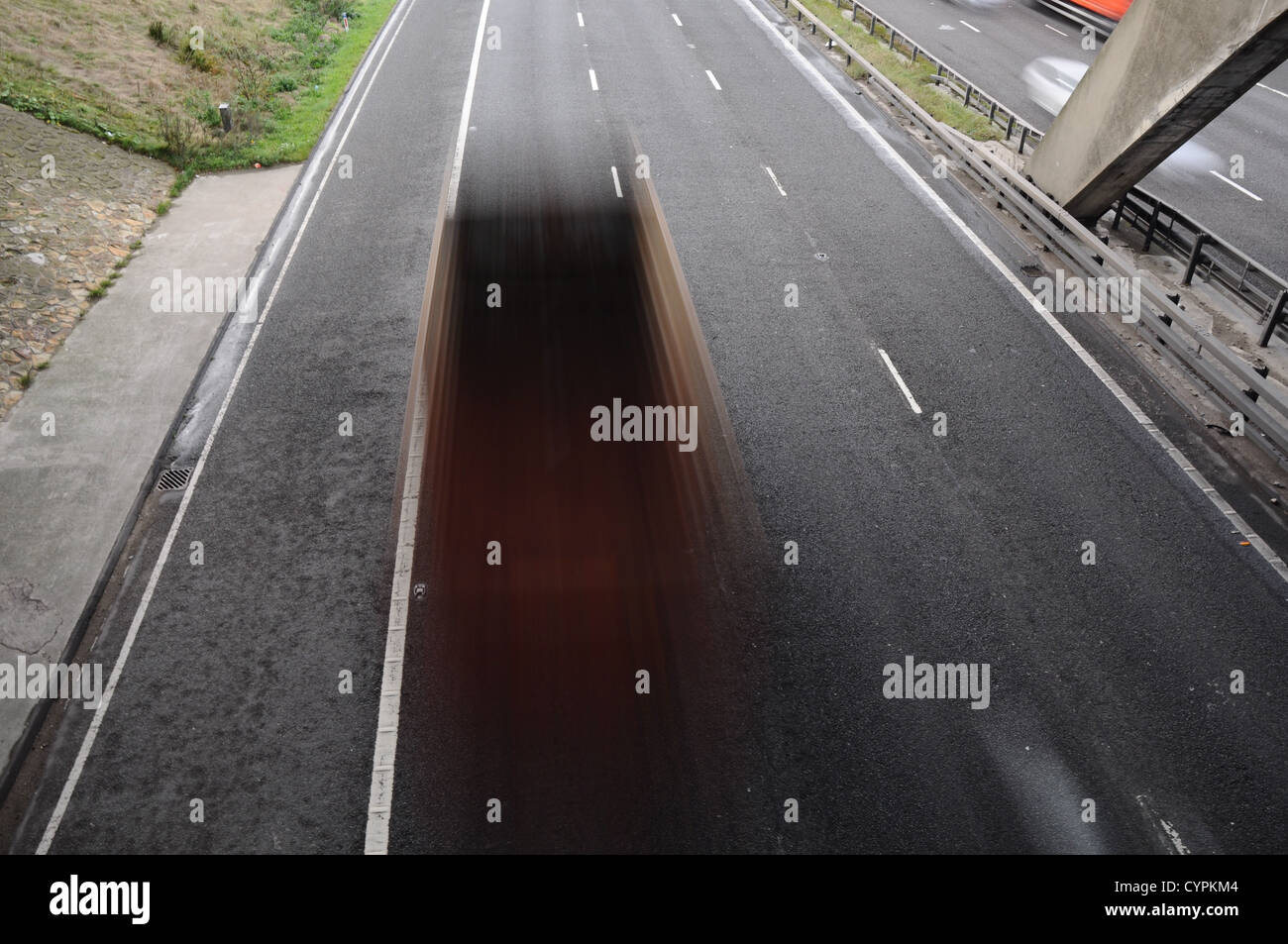 Cars and lorries driving under a motorway bridge in England Stock Photo ...