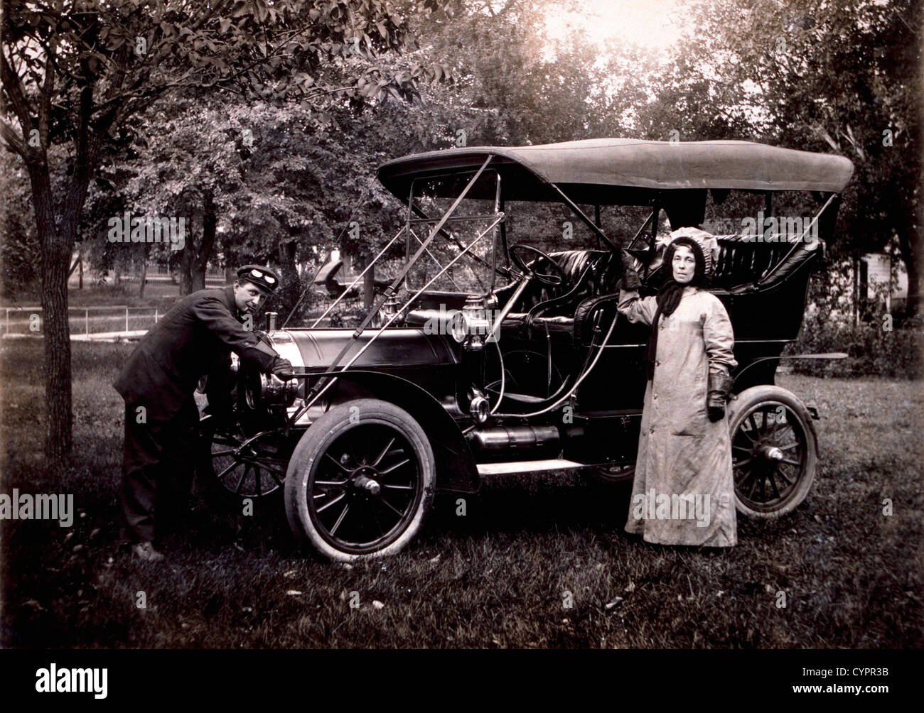 Woman Standing Beside Maxwell Touring Car and Driver Cranking Engine ...