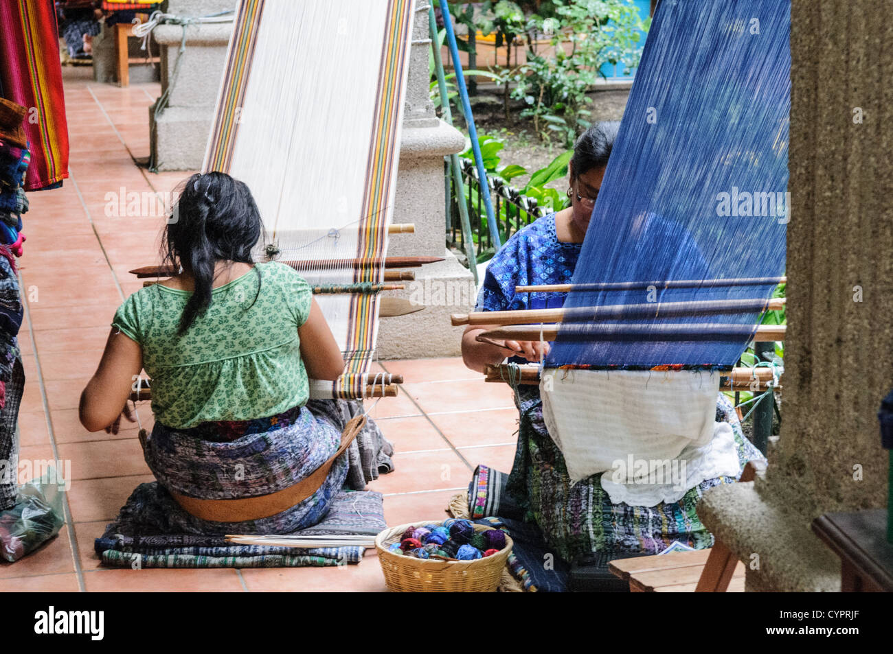 ANTIGUA GUATEMALA, Guatemala — A woman weaving with a traditional ...