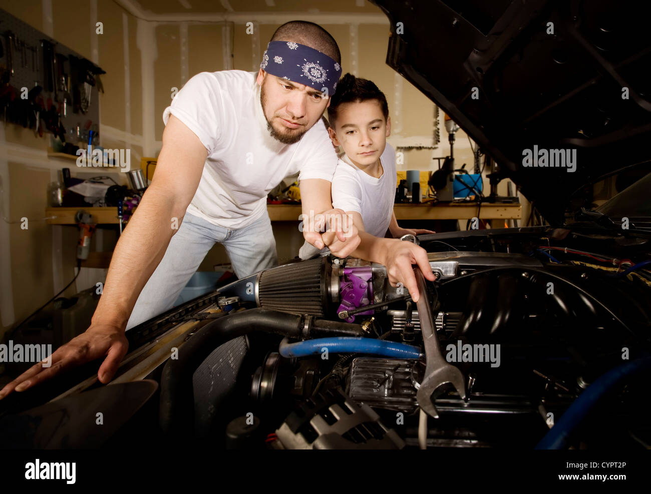 Hispanic father and son working on car engine in garage Stock Photo - Alamy