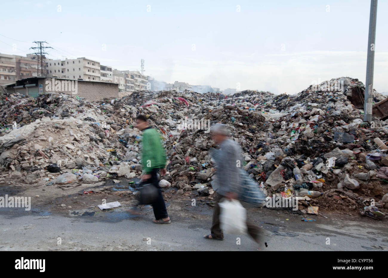 November 8, 2012 - Aleppo, Syria: Men walk by a trash dump in Geser Hag ...