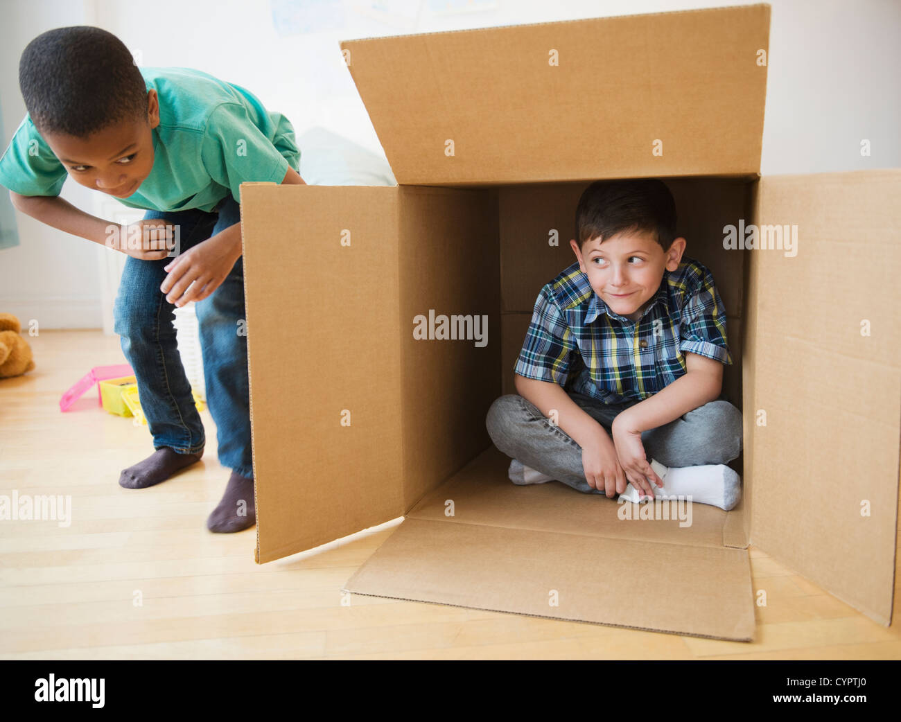 Boys playing with cardboard box Stock Photo - Alamy