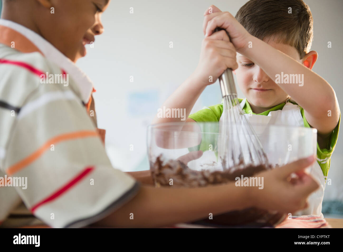 Boys mixing cake batter together Stock Photo - Alamy