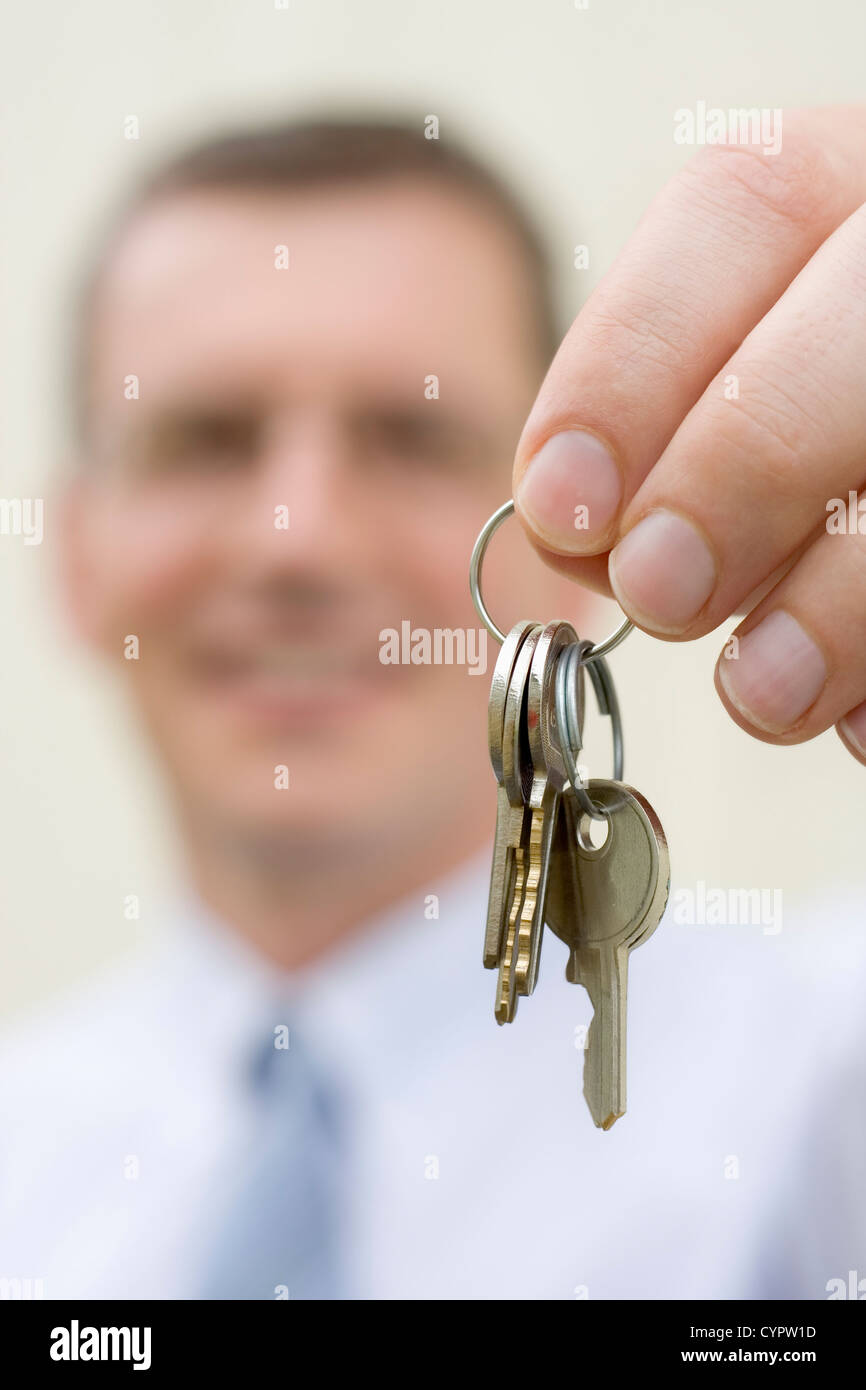 Smiling businessman handing over keys Stock Photo - Alamy