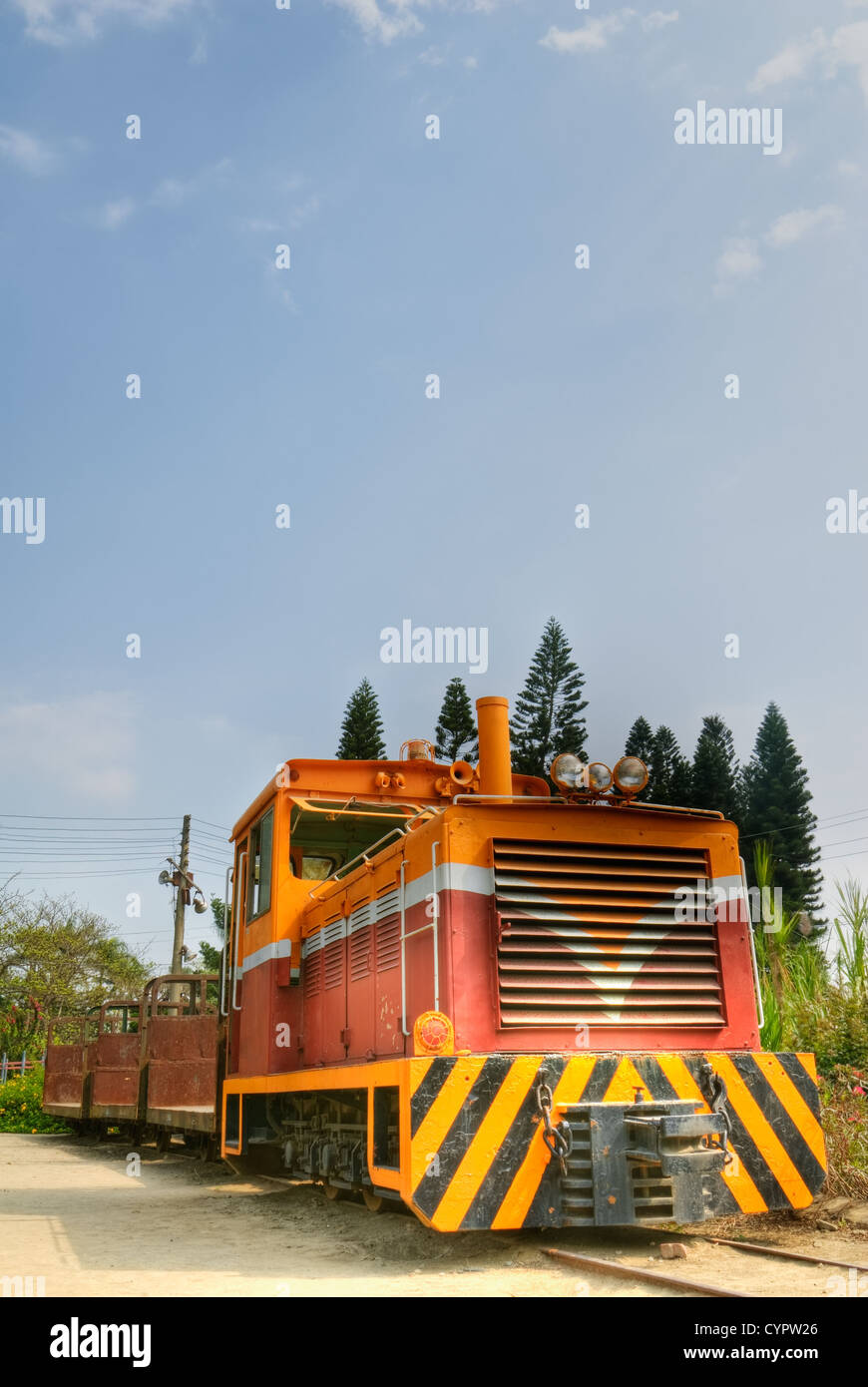 Old railway engine in orange color under blue sky Stock Photo - Alamy