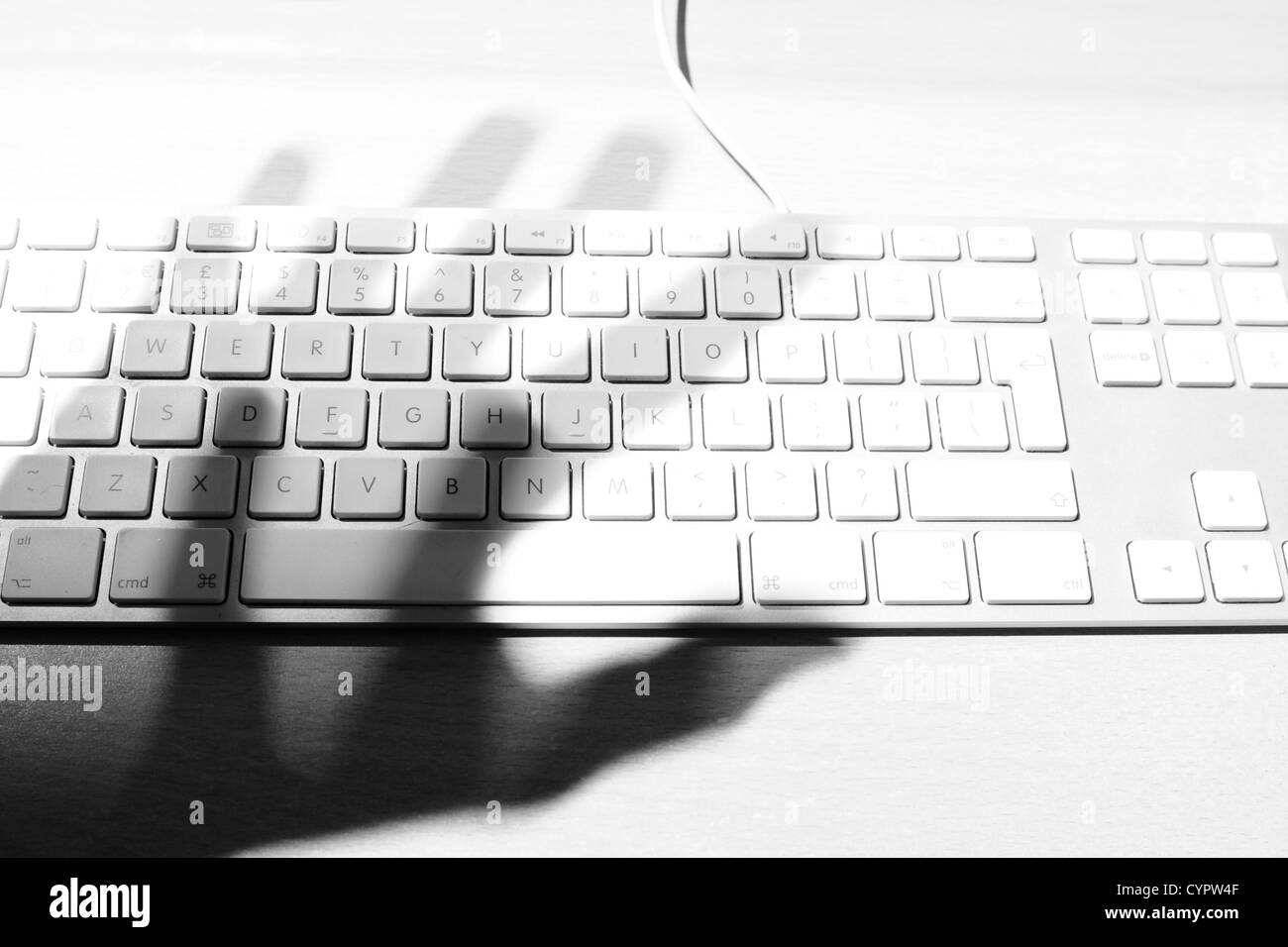 Shadowy hand over a keyboard implying data theft and IT Fraud Stock ...