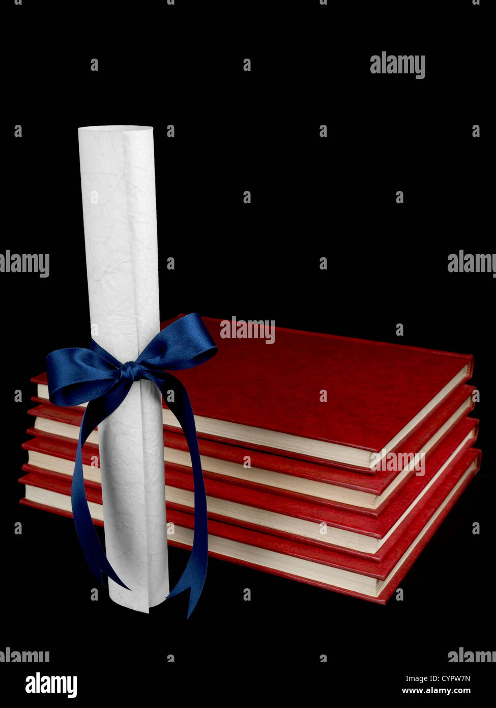 A diploma with blue ribbon and several books aside. Isolated on black ...