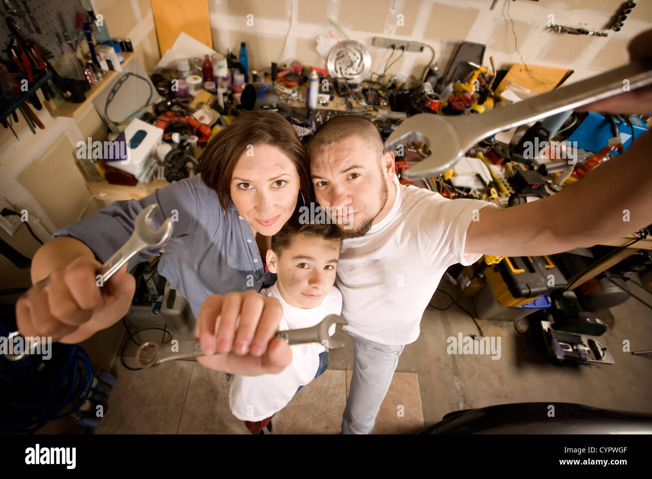 Funny Hispanic family in garage with crescent wrenches Stock Photo - Alamy