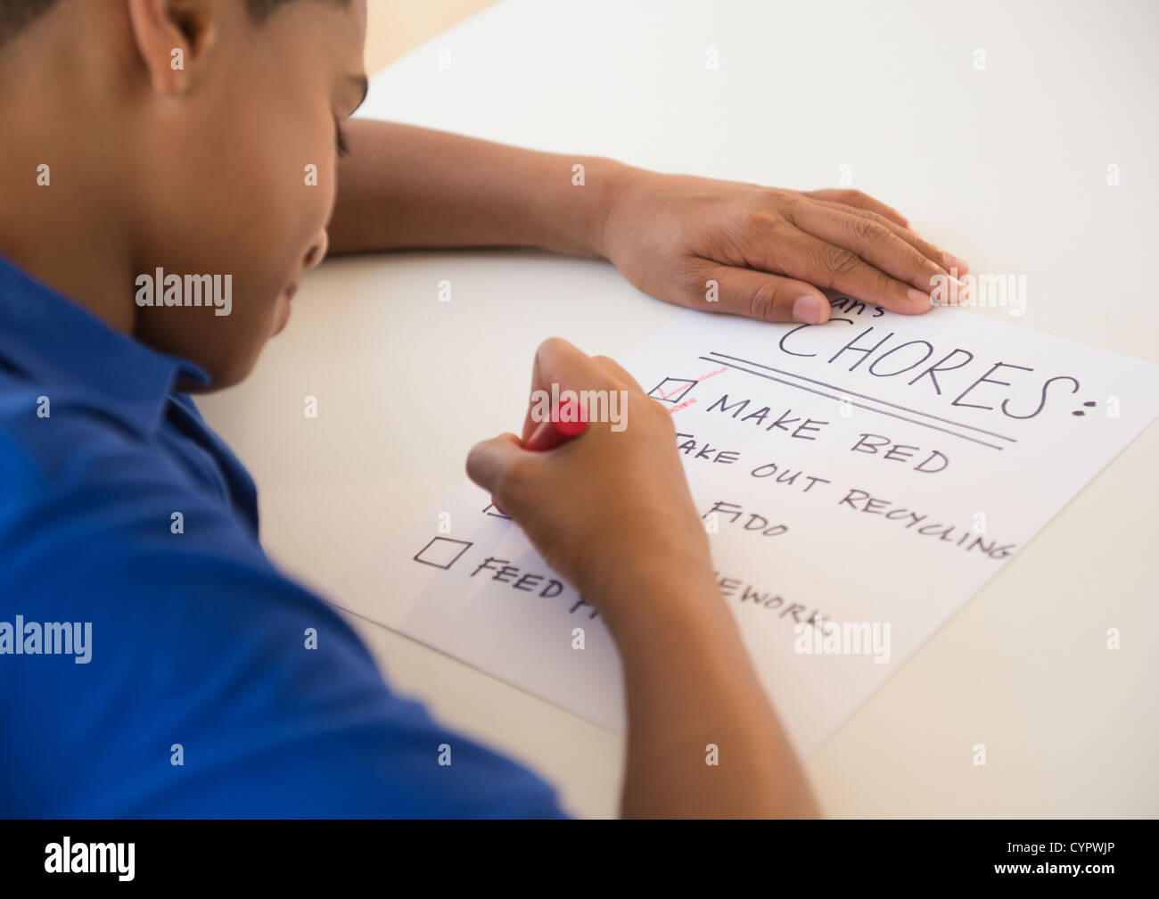 Hispanic boy checking off chore list Stock Photo - Alamy