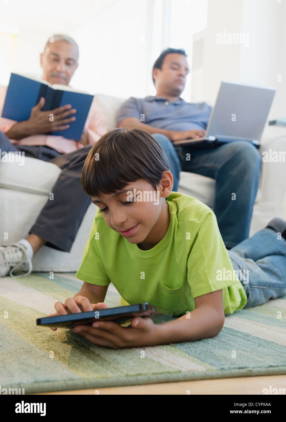 Hispanic boy laying on floor using digital tablet Stock Photo - Alamy