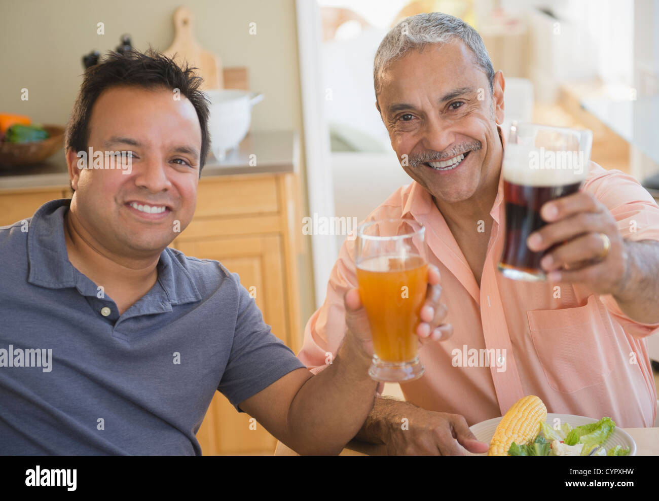 Hispanic father and son drinking Stock Photo - Alamy